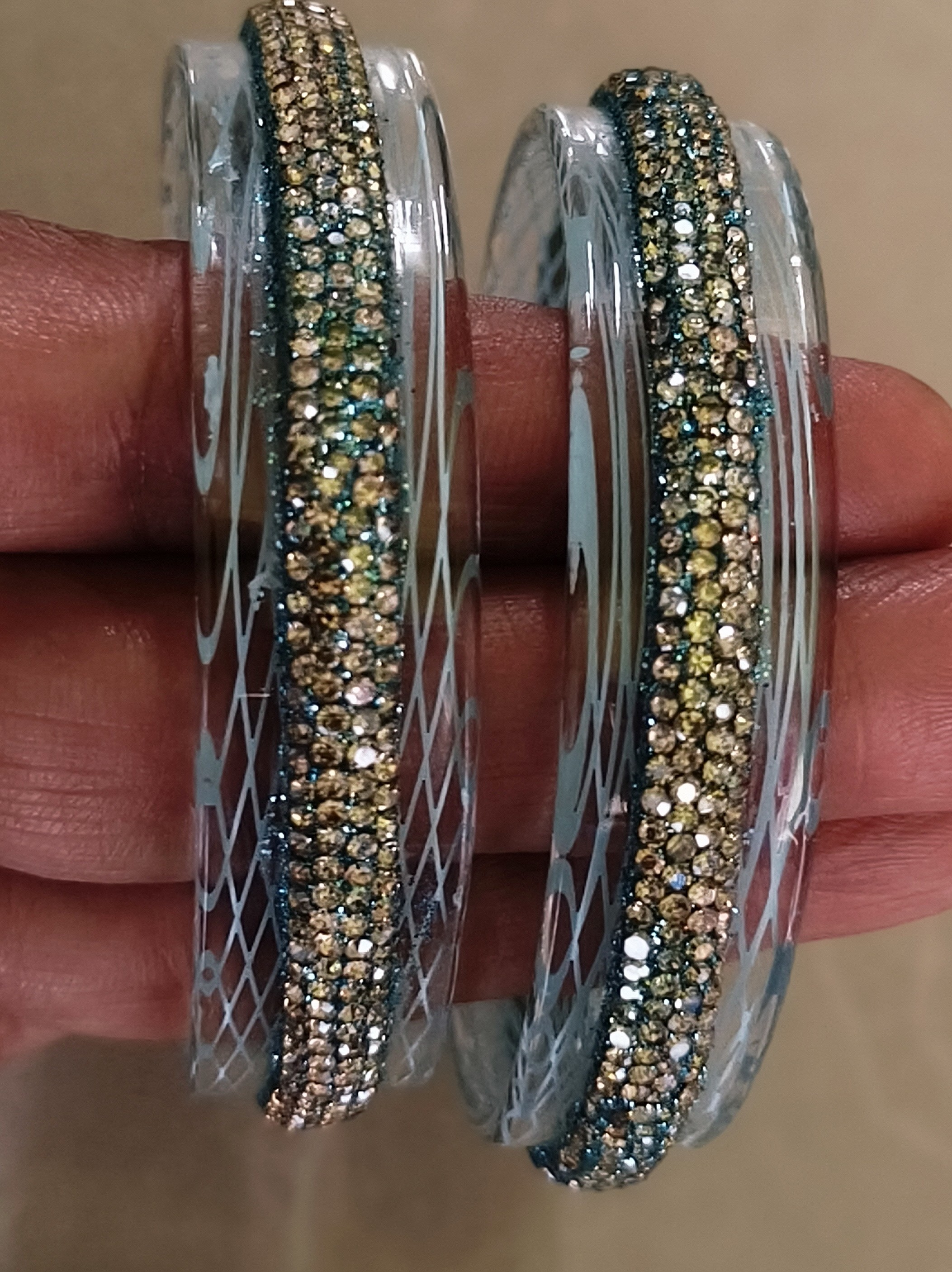 pair of elegant glass bangles with a central strip of glittering stones ...